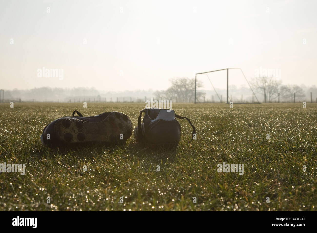 football boots on a empty football pitch,frosty winter morning sunrise ...