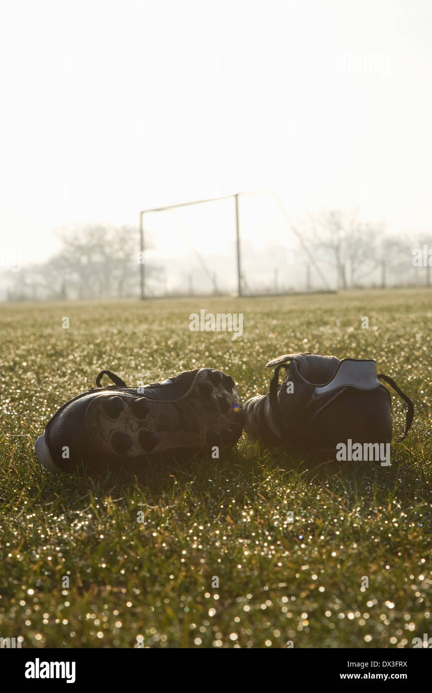 football boots on a empty football pitch,frosty winter morning sunrise ...