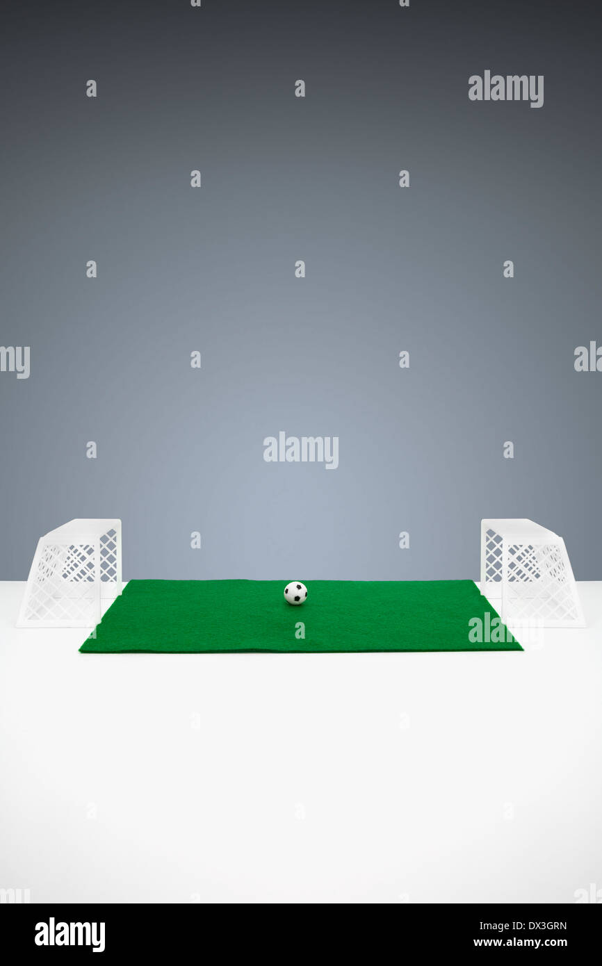 Small table top football goal posts, football and green felt pitch on ...