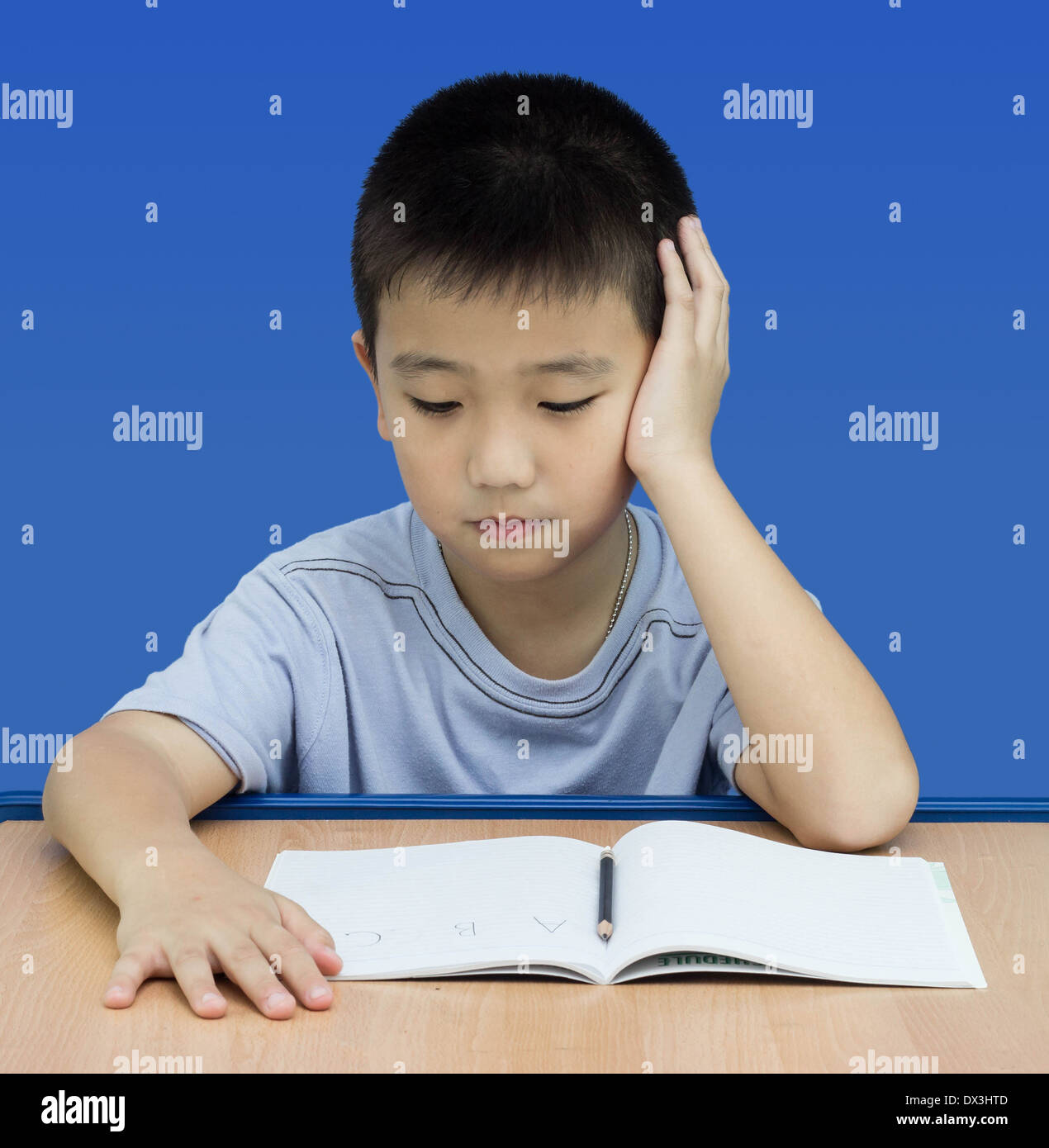 Asian boy reading book on blue background Stock Photo - Alamy