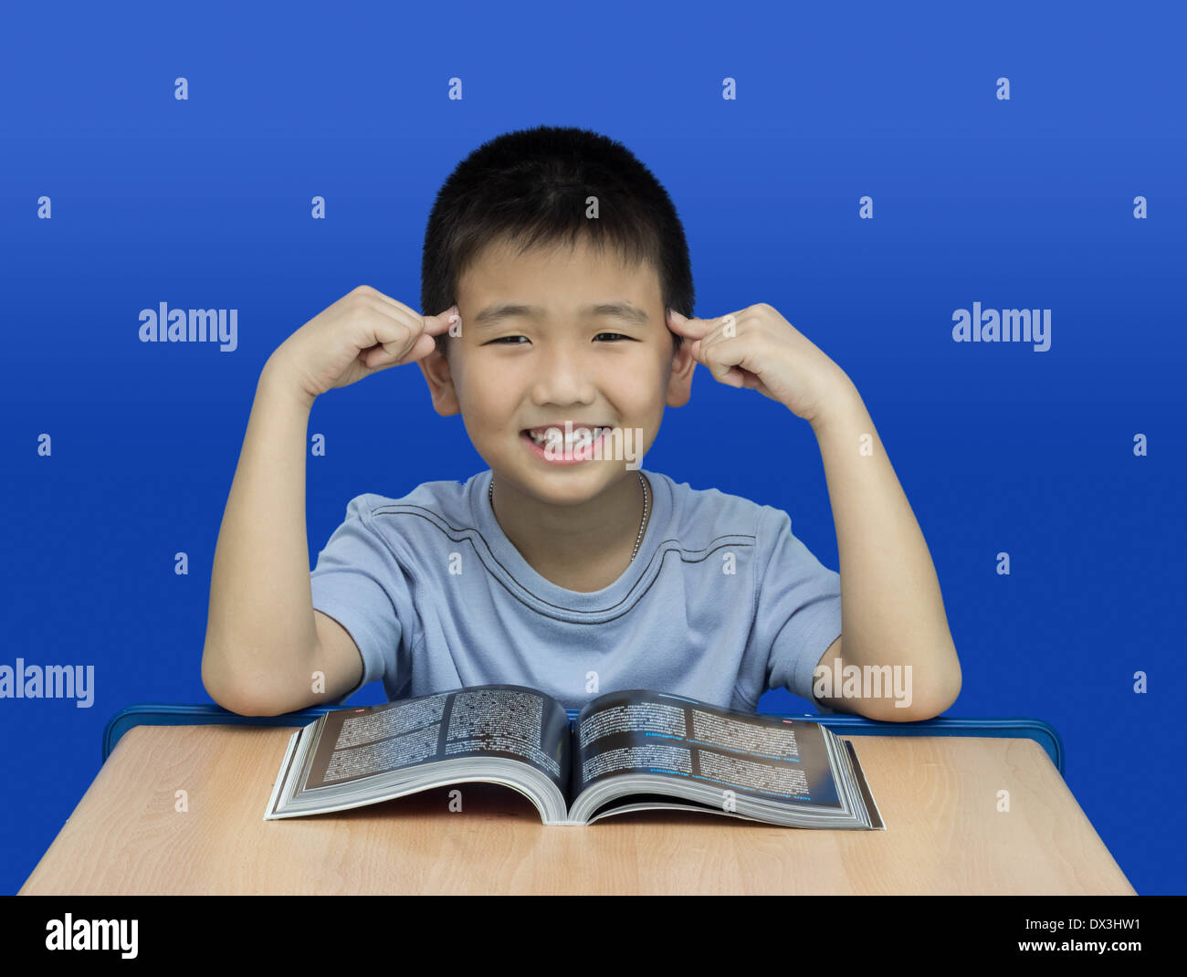Asian boy success reading book on blue background Stock Photo - Alamy