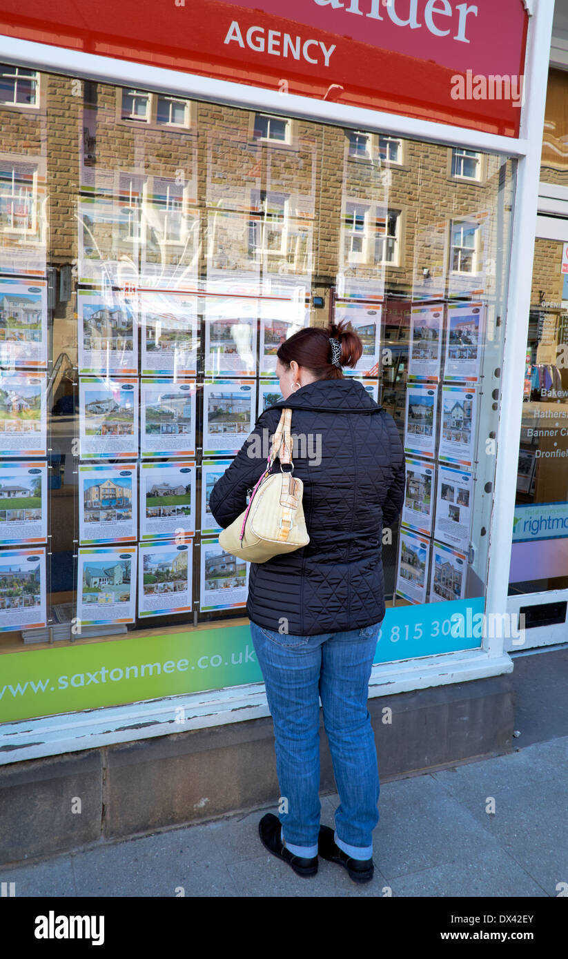 A middle aged woman looking in an estate agents window Bakewell ...