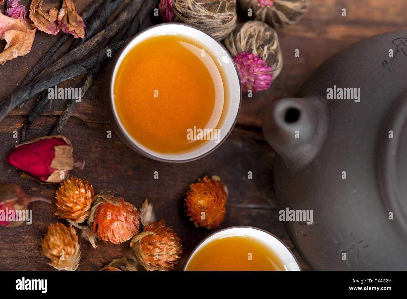 Chinese style herbal floral tea over wood table with raw ingredients ...