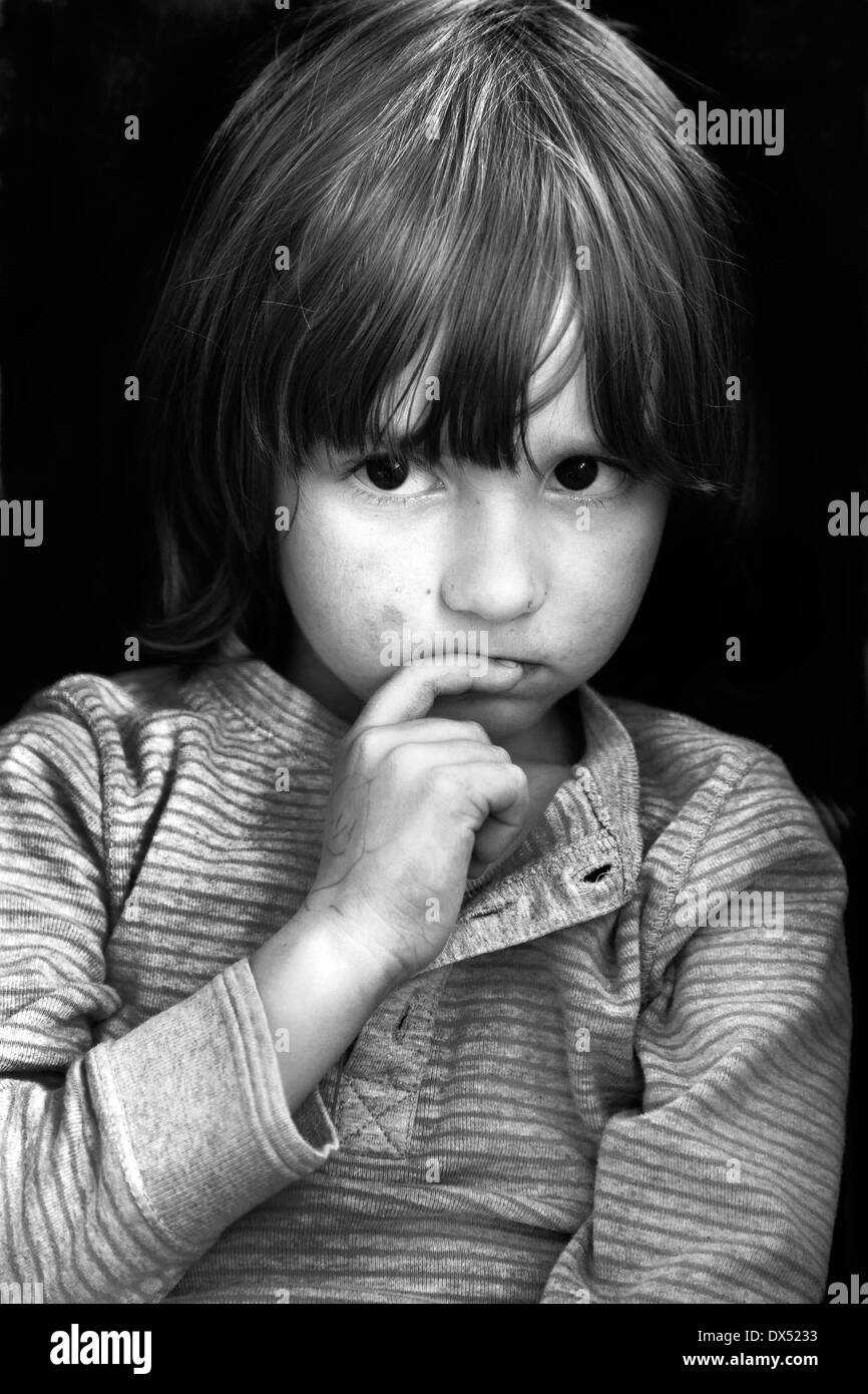 Cute 5 year old boy holding his hand to his mouth Stock Photo - Alamy