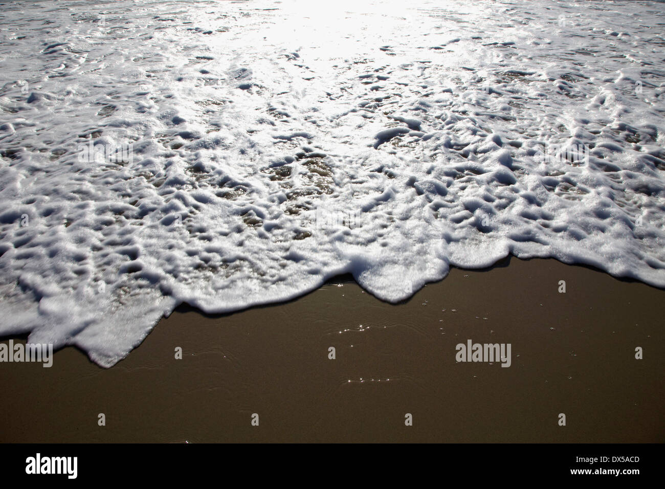 Surf washes up on the beach Stock Photo - Alamy