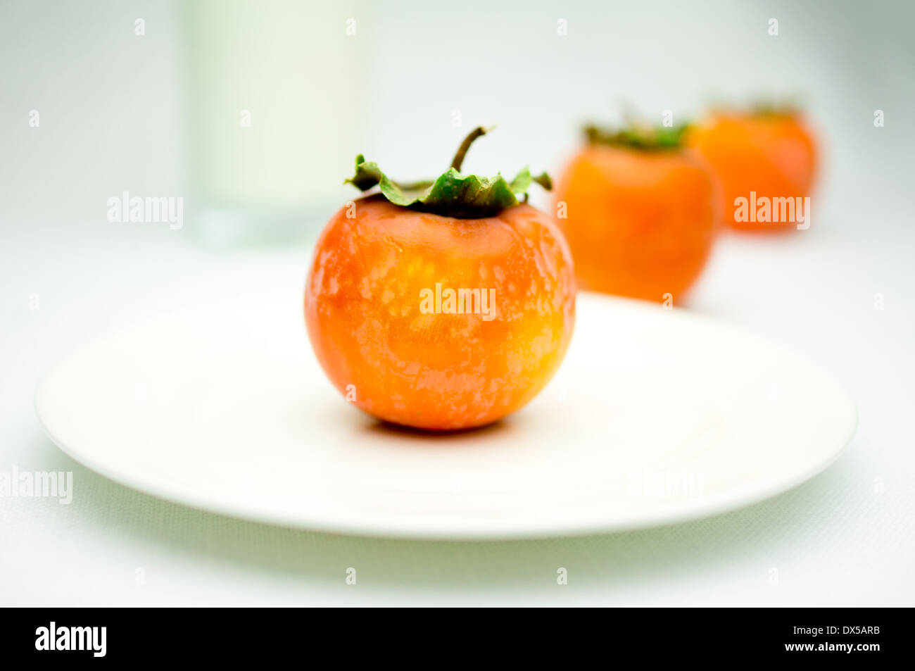Persimmon on a plate. Against the background of the persimmon is not in ...