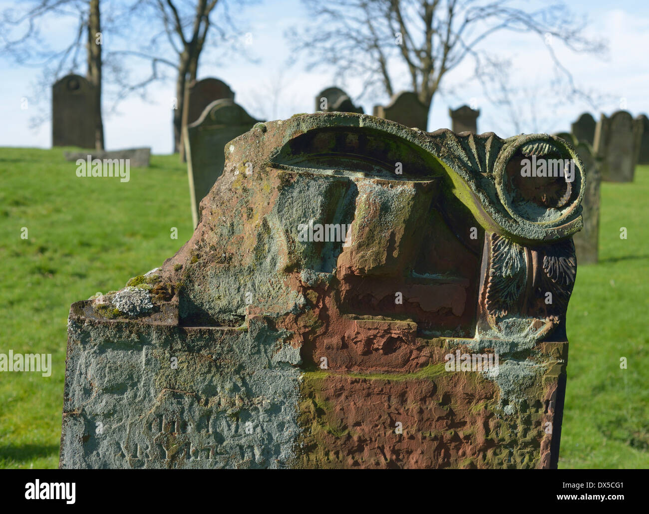 Badly eroded sandstone gravestone with book design. All Saints Church ...