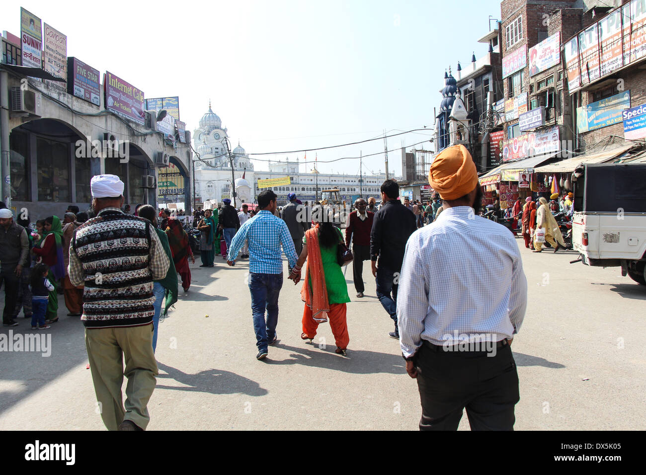 Married couple and other devotees in a crowded street walking towards ...