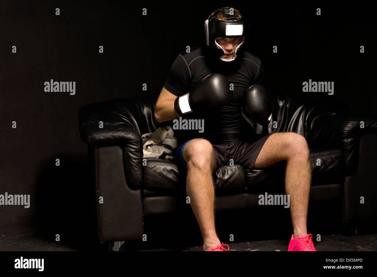 Boxer sitting on a couch getting ready for a fight putting on his ...