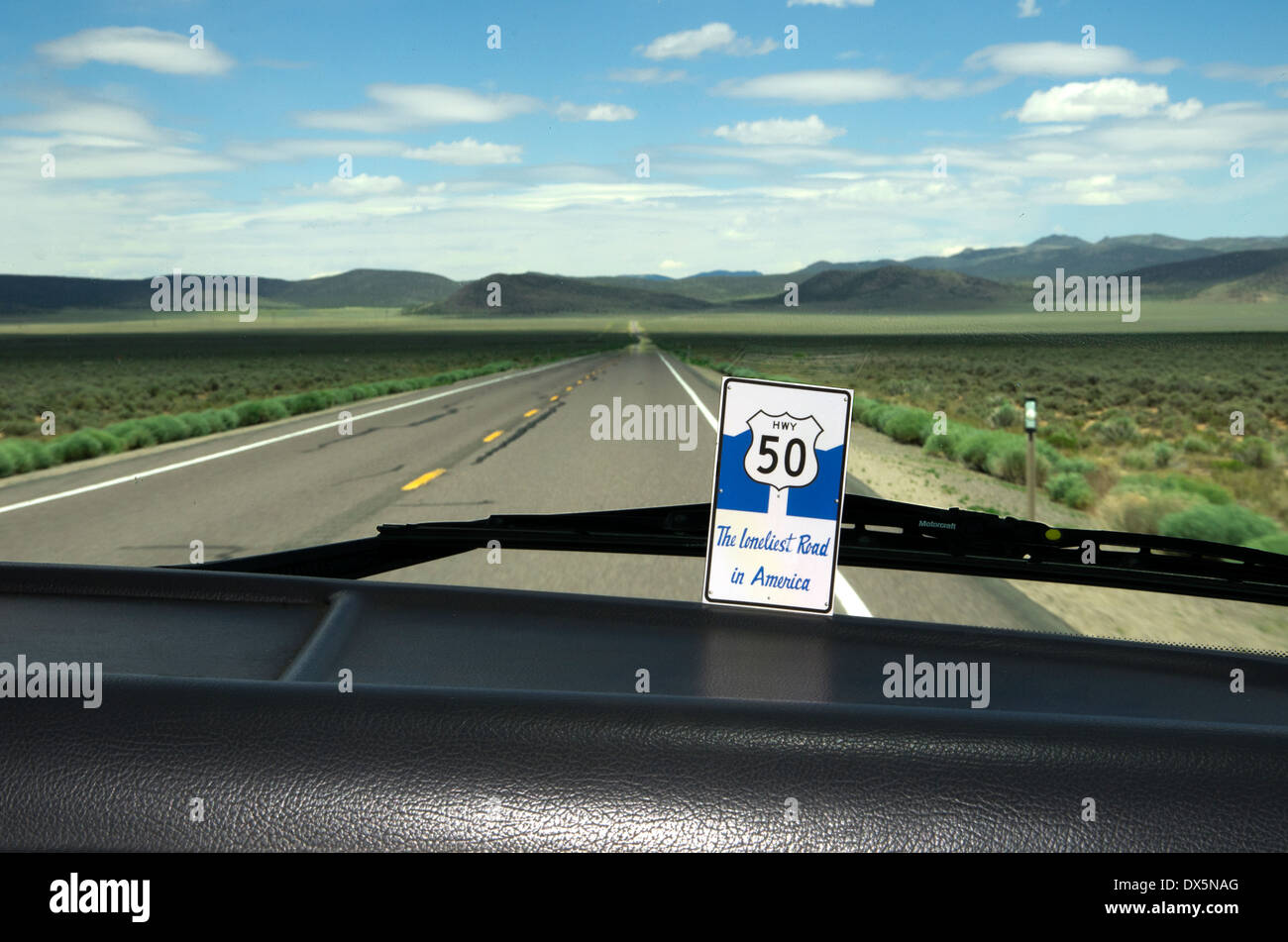 "Loneliest Road in America" magent sits on dashboard, view out the ...