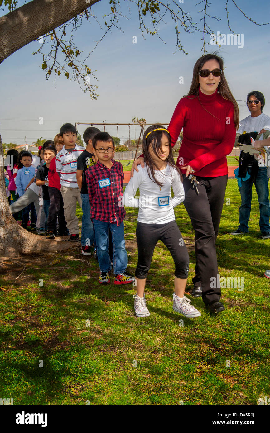 A teacher leads her Asian American, Caucasian, and Hispanic first grade ...