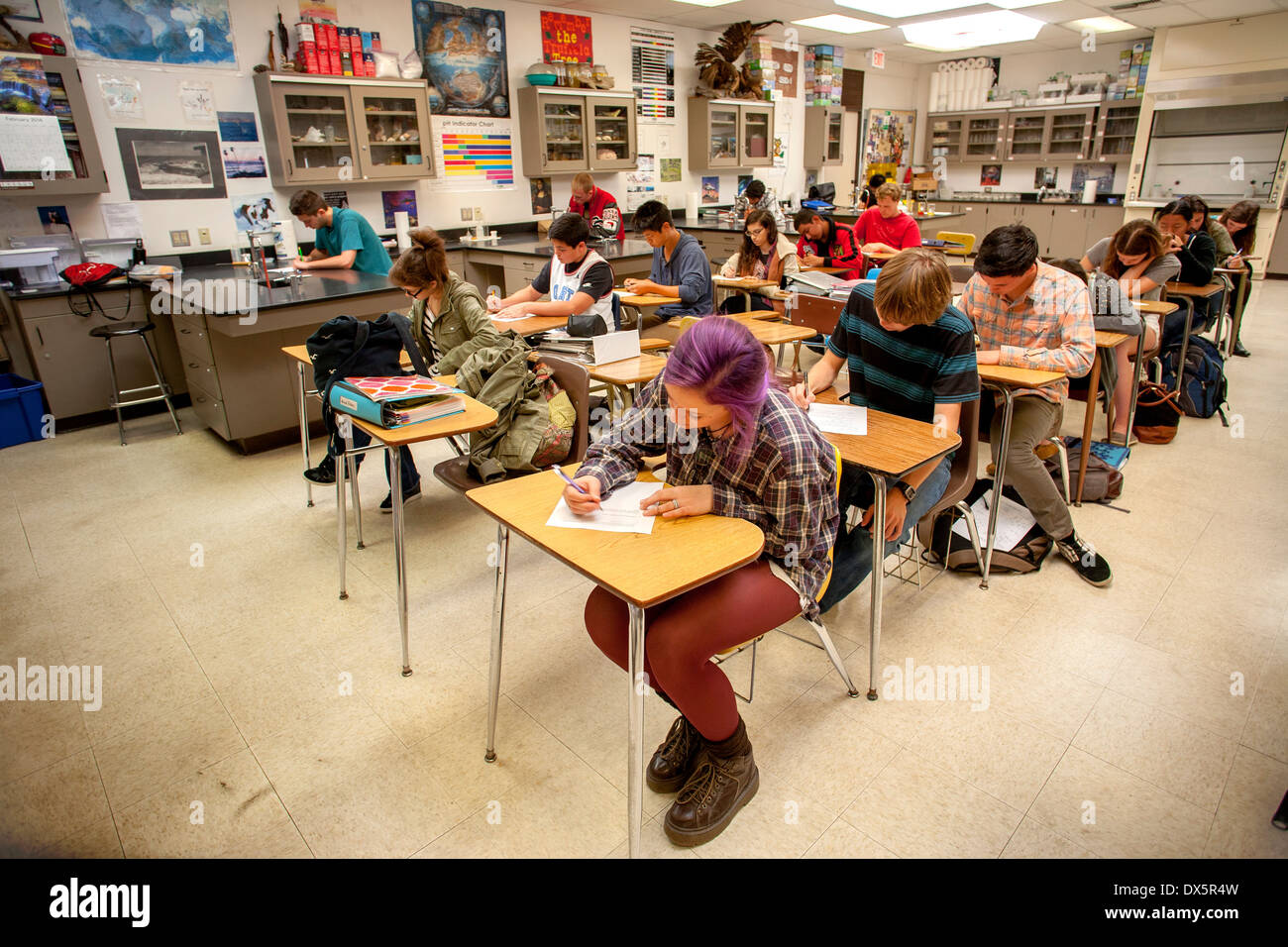 Teen high school chemistry students taking a classroom examination in ...