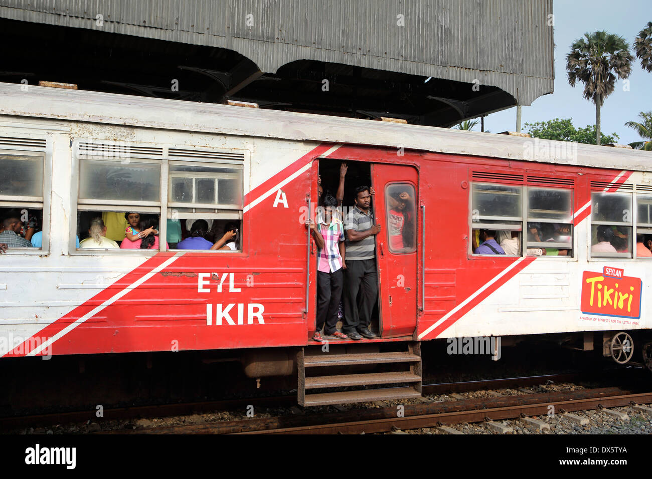 People hanging from open doors of commuter train passing through Mount ...