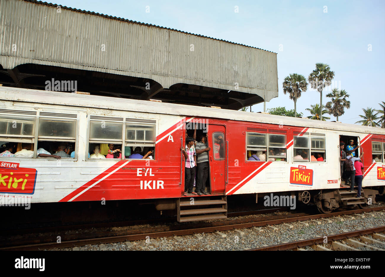 People hanging from open doors of commuter train passing through Mount ...