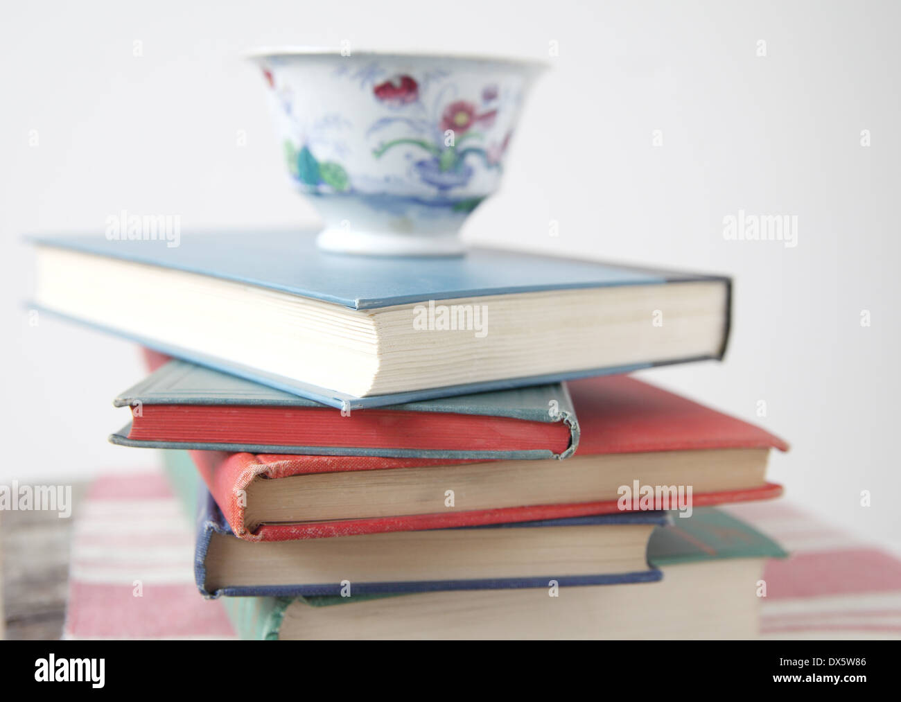 old cup on top of a stack of books Stock Photo - Alamy