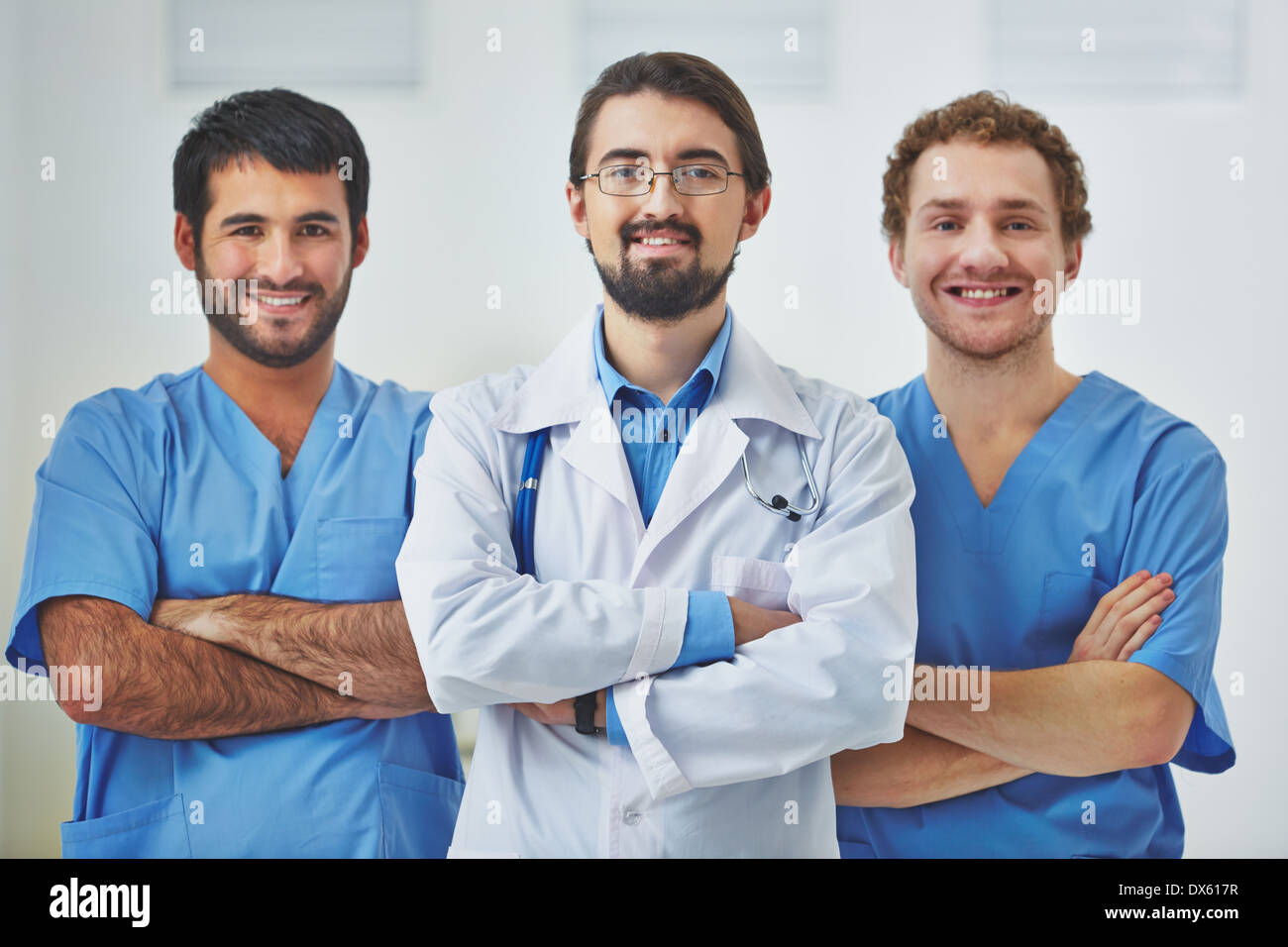 Portrait of three successful clinicians in uniform looking at camera ...