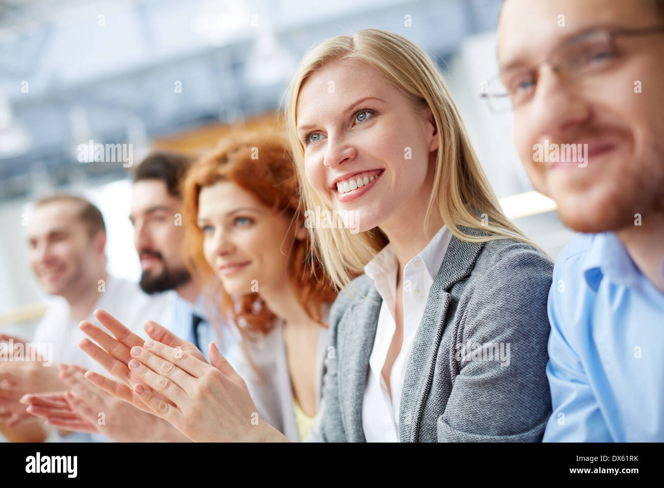 Closeup image of a smiley business leader clapping at the seminar with ...