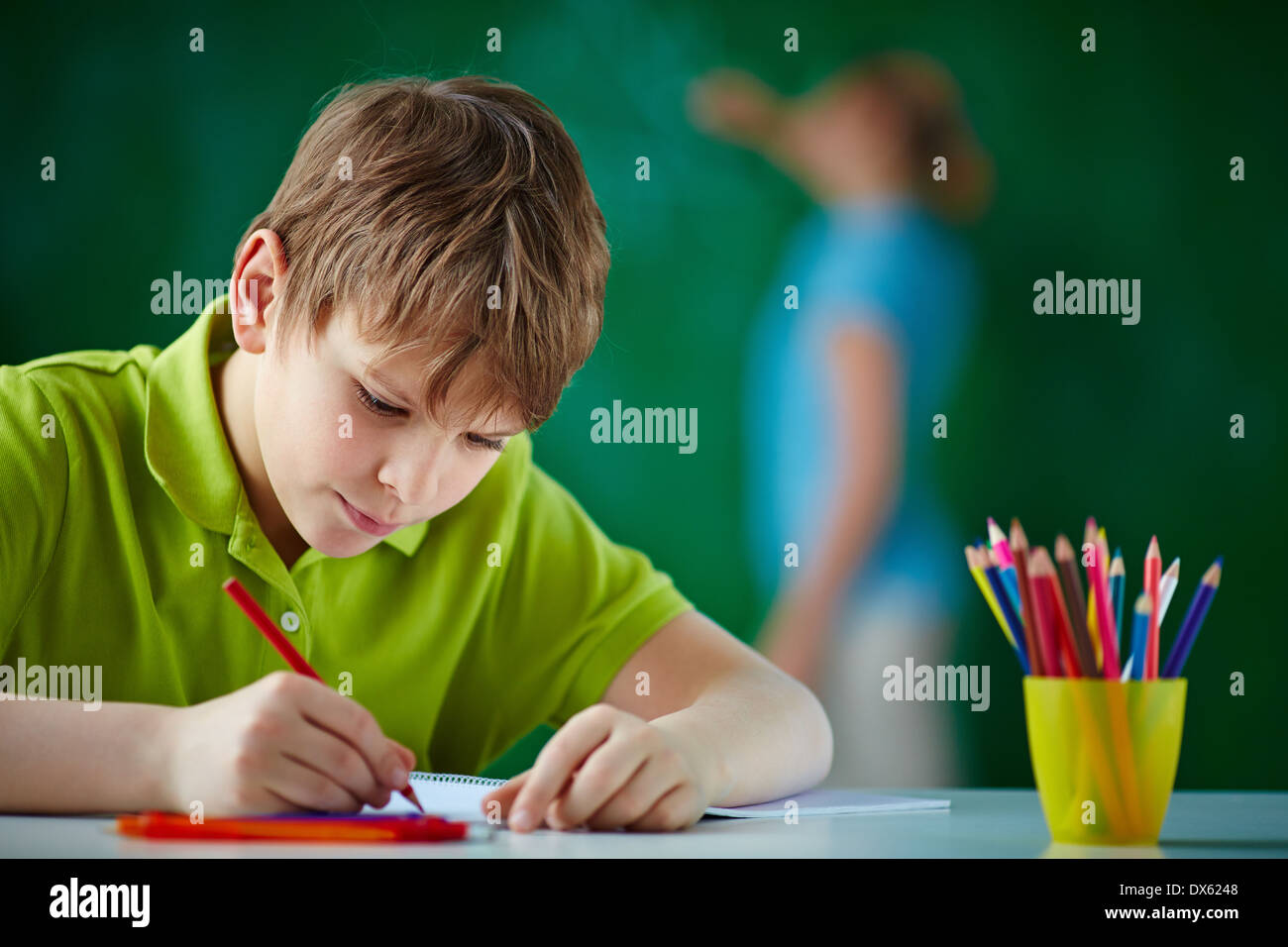 Portrait of cute schoolboy drawing with colorful pencils Stock Photo ...