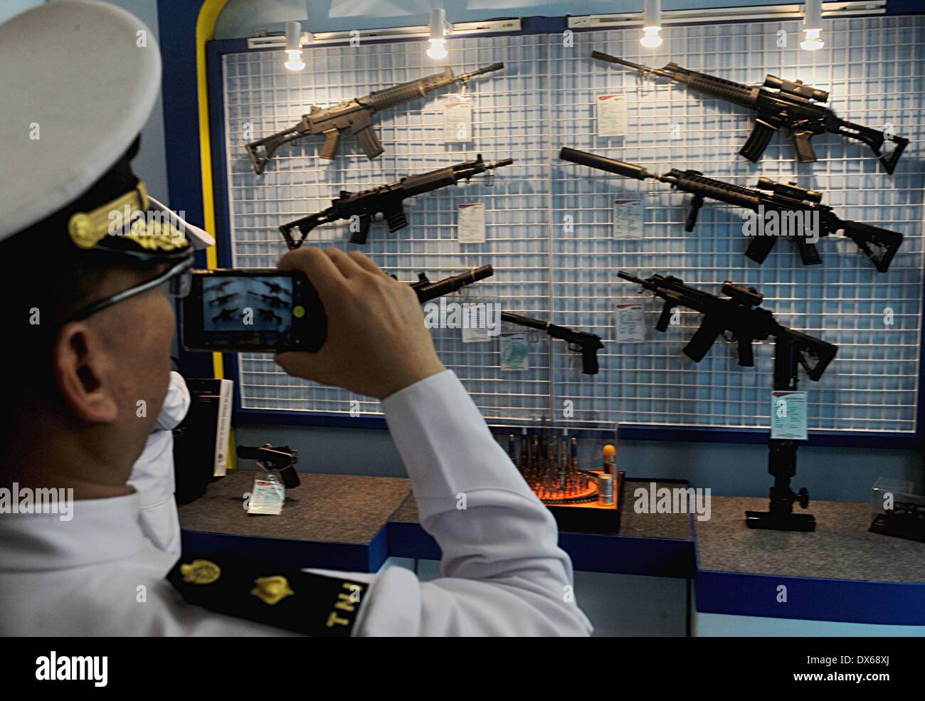 Jakarta, Indonesia. 19th Mar, 2014. A visitor takes photo of guns ...