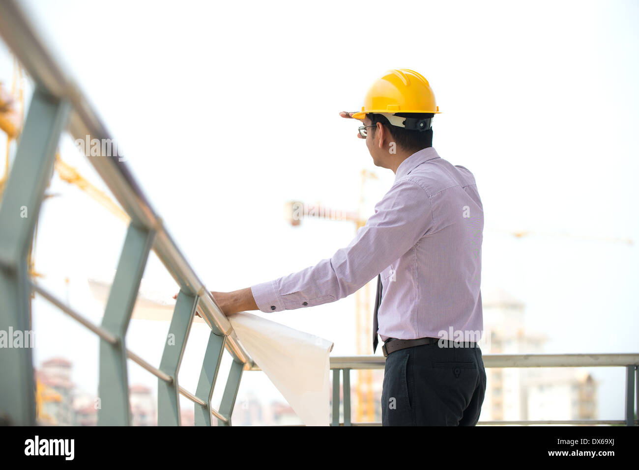 indian male architect reading plans with construction background Stock ...