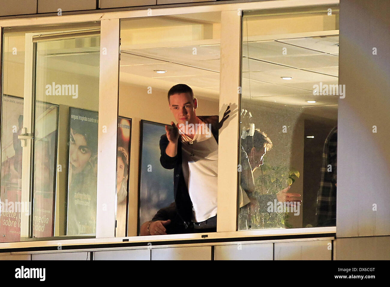 Liam Payne of One Direction leans out of a TV studio window to greet ...