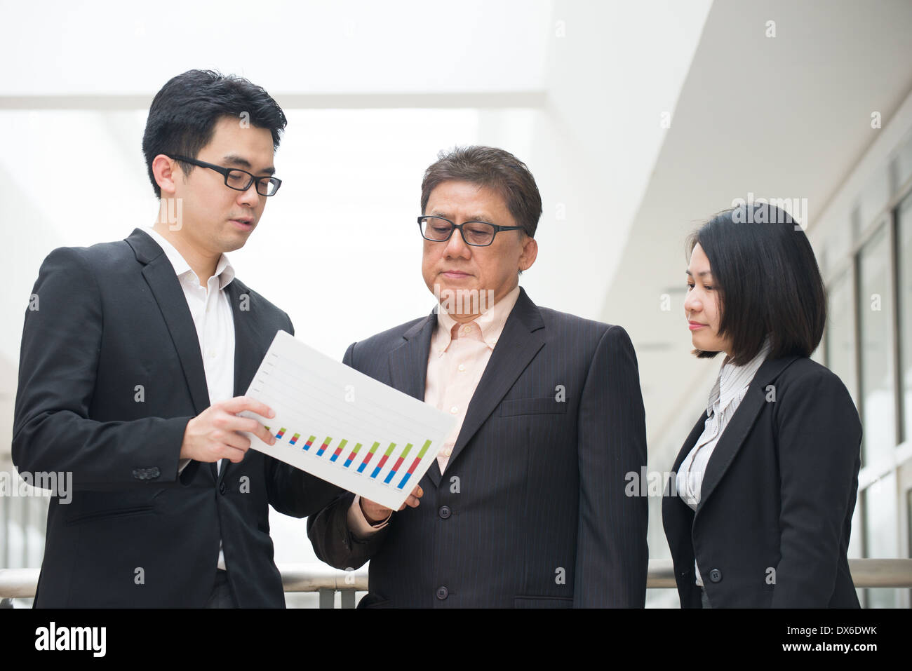 asian business team reporting to senior ceo with office background ...