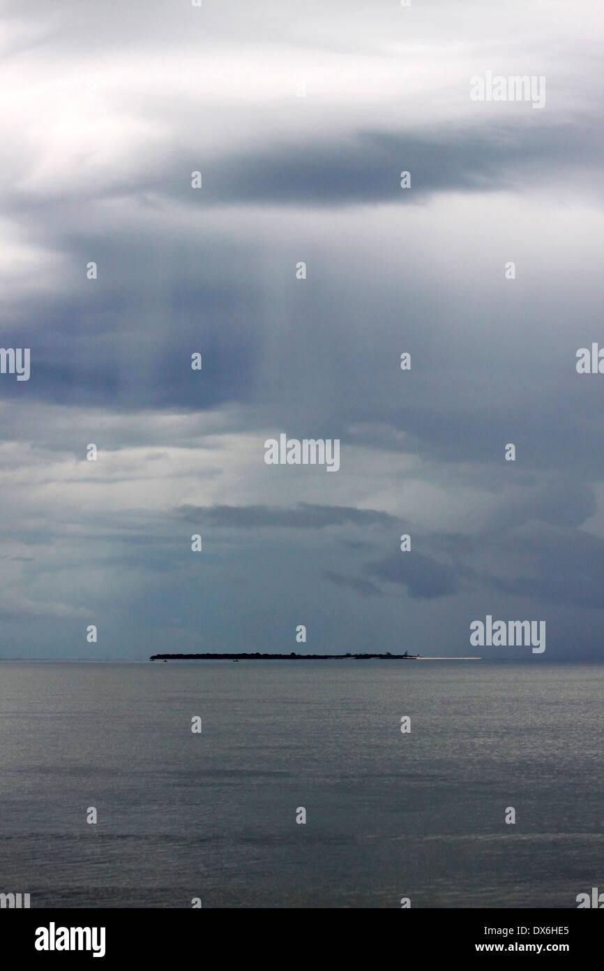 Tropical Island far away in the horizon line under tropical rain ...