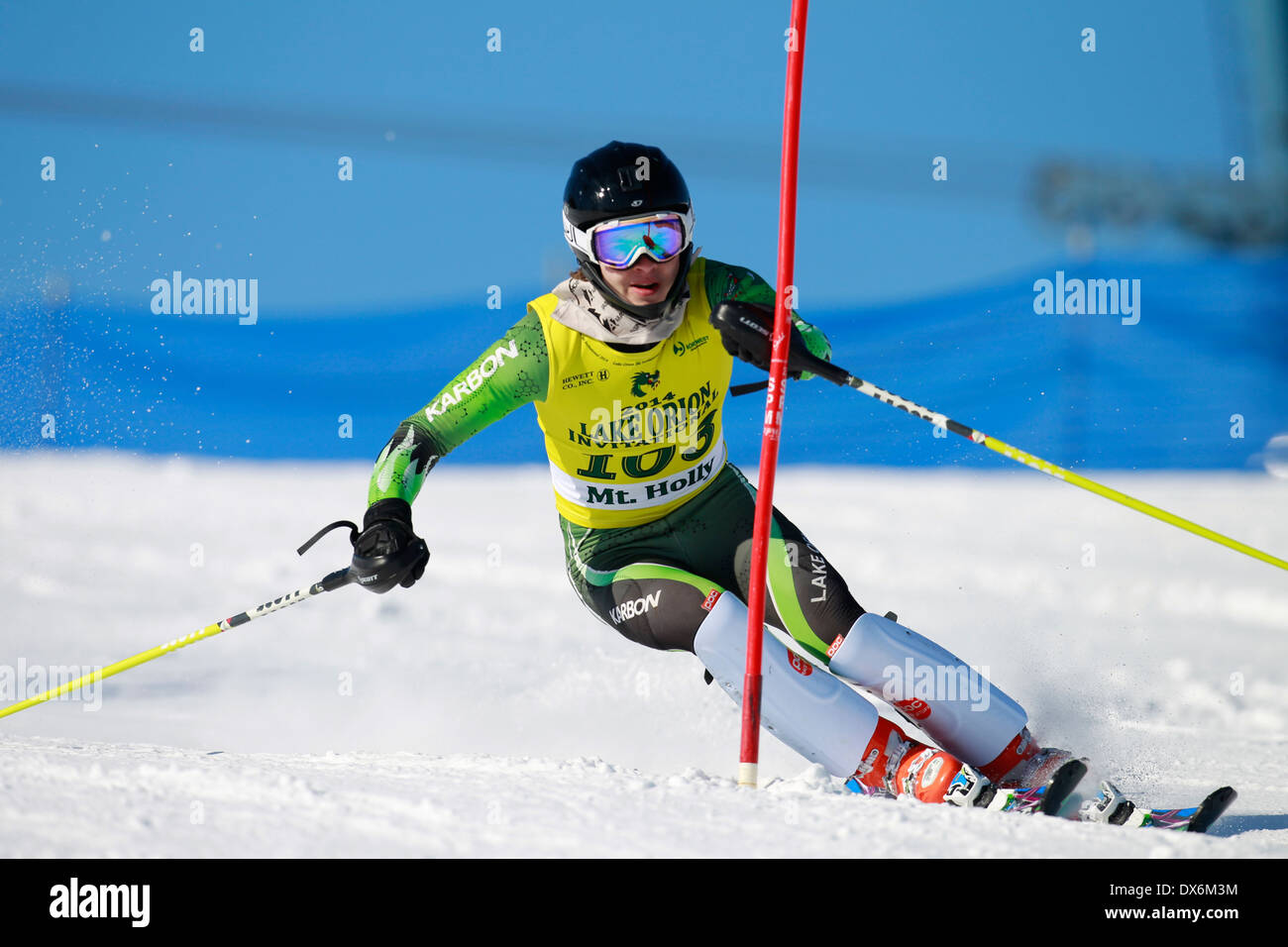 An alpine skier turning at a gate while racing on the slalom course ...