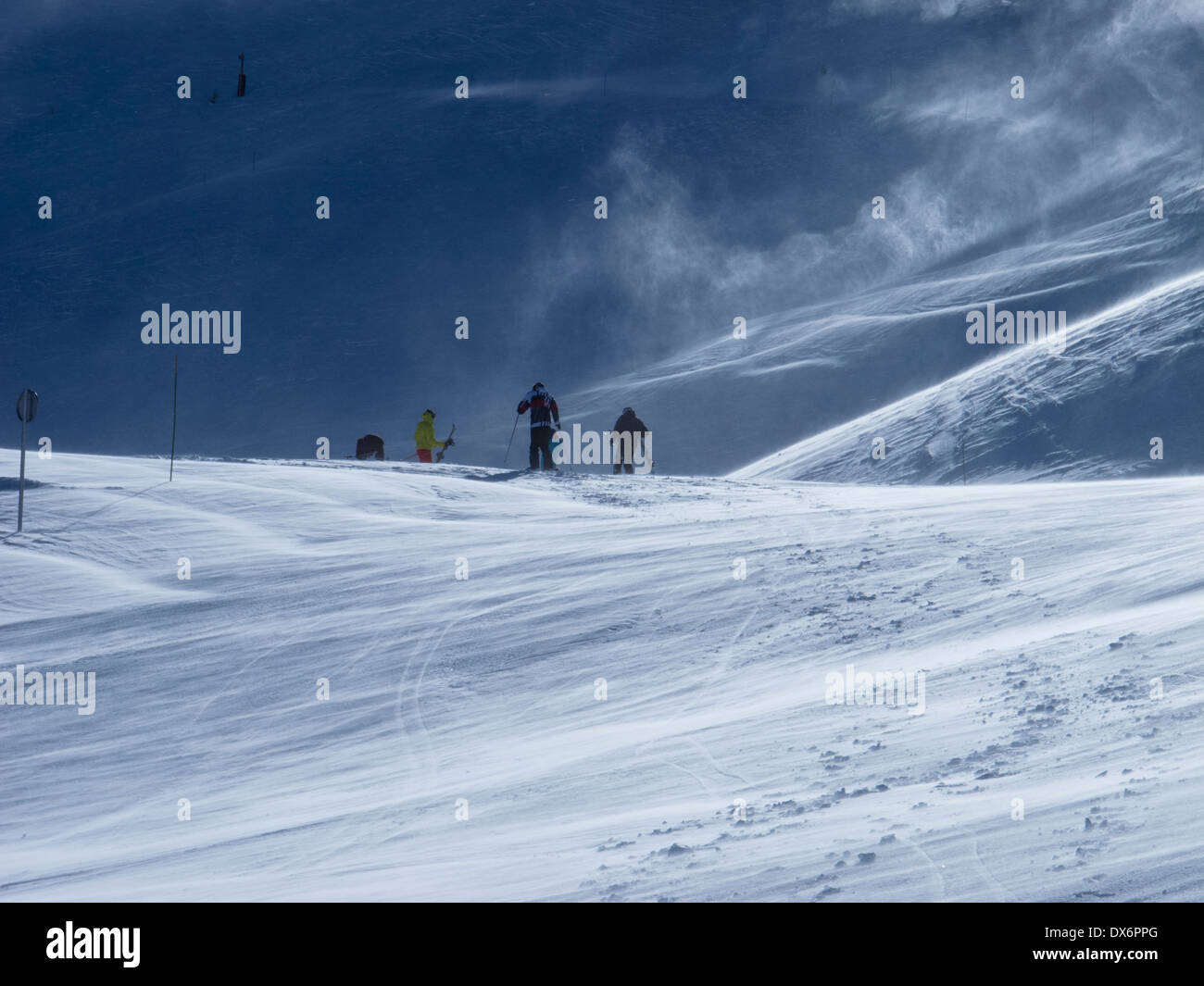 Mountain top in wind storm. High wind blows snow off a mountain ridge ...