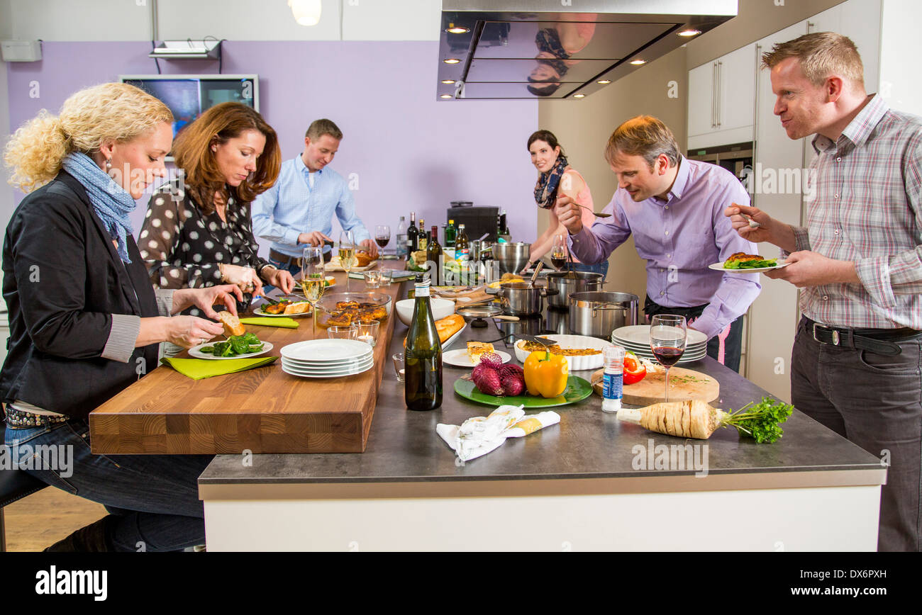 Friends cooking together in a kitchen. Preparing a meal together, self ...