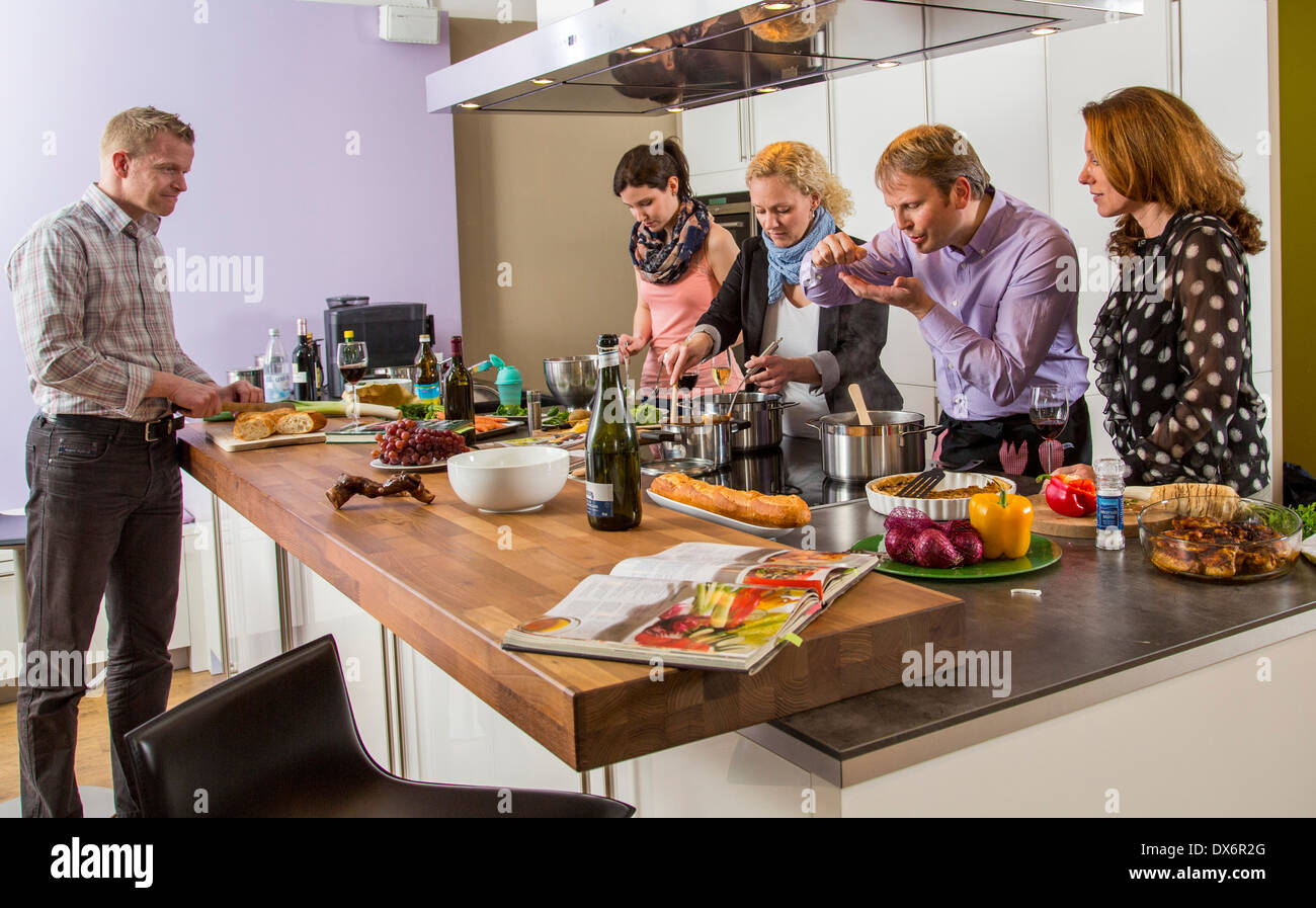 Friends cooking together in a kitchen. Preparing a meal together, self ...