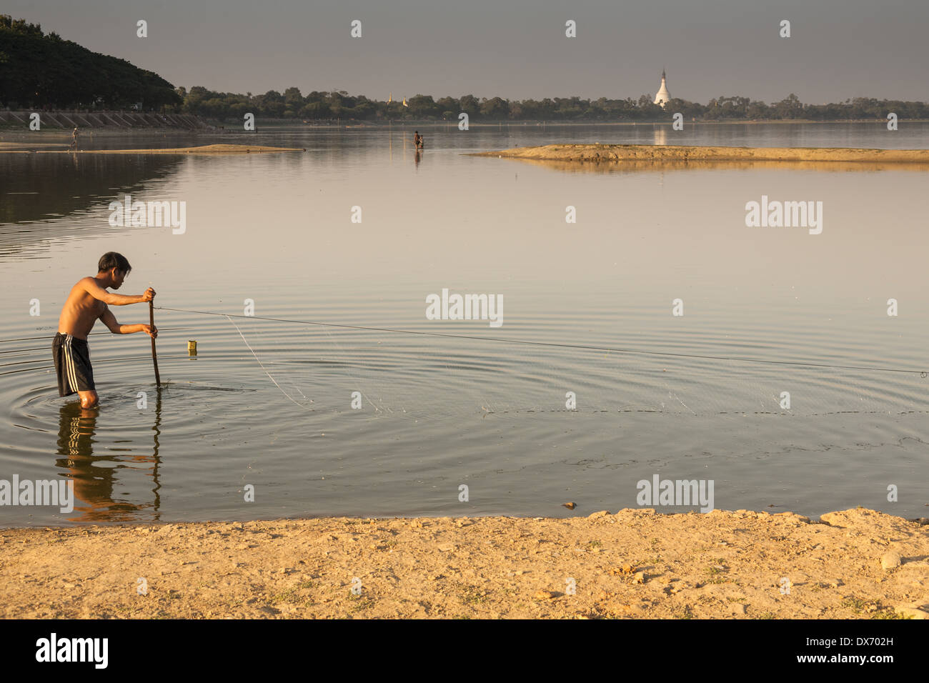 Fisherman placing fishing nets in Taungthaman Lake, Amarapura, Mandalay ...