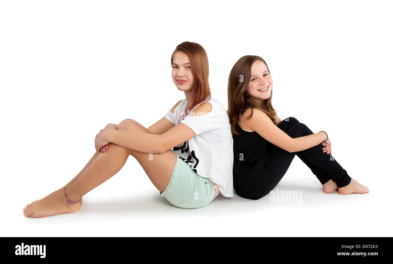 two teenage girls sitting back to back Stock Photo - Alamy