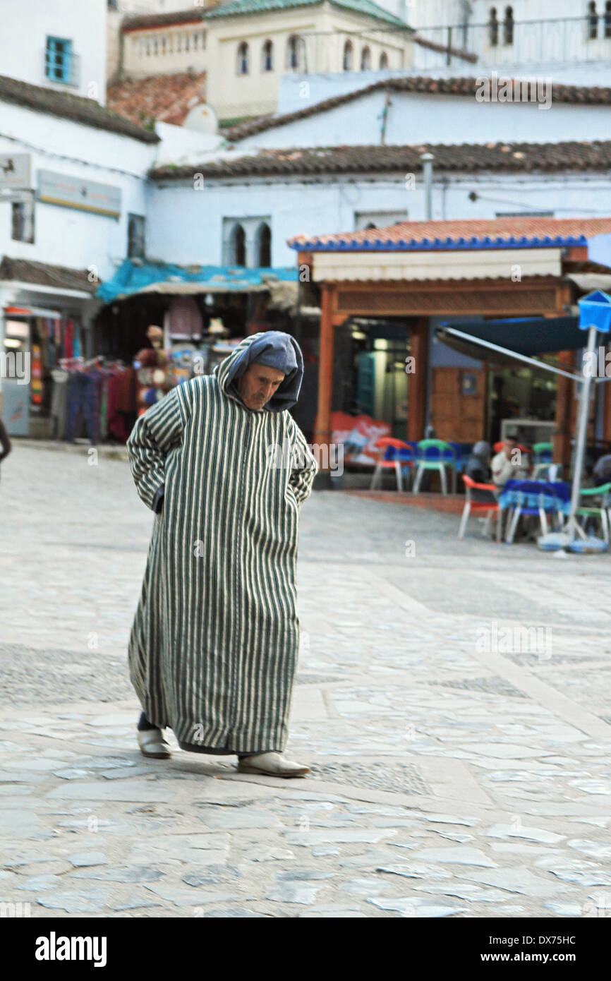 Traditional Moroccan man wearing a Djellaba walking in the town of ...