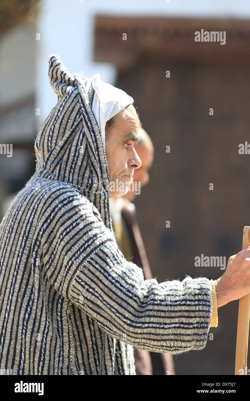 Traditional Moroccan man wearing a Djellaba walking in the town of ...