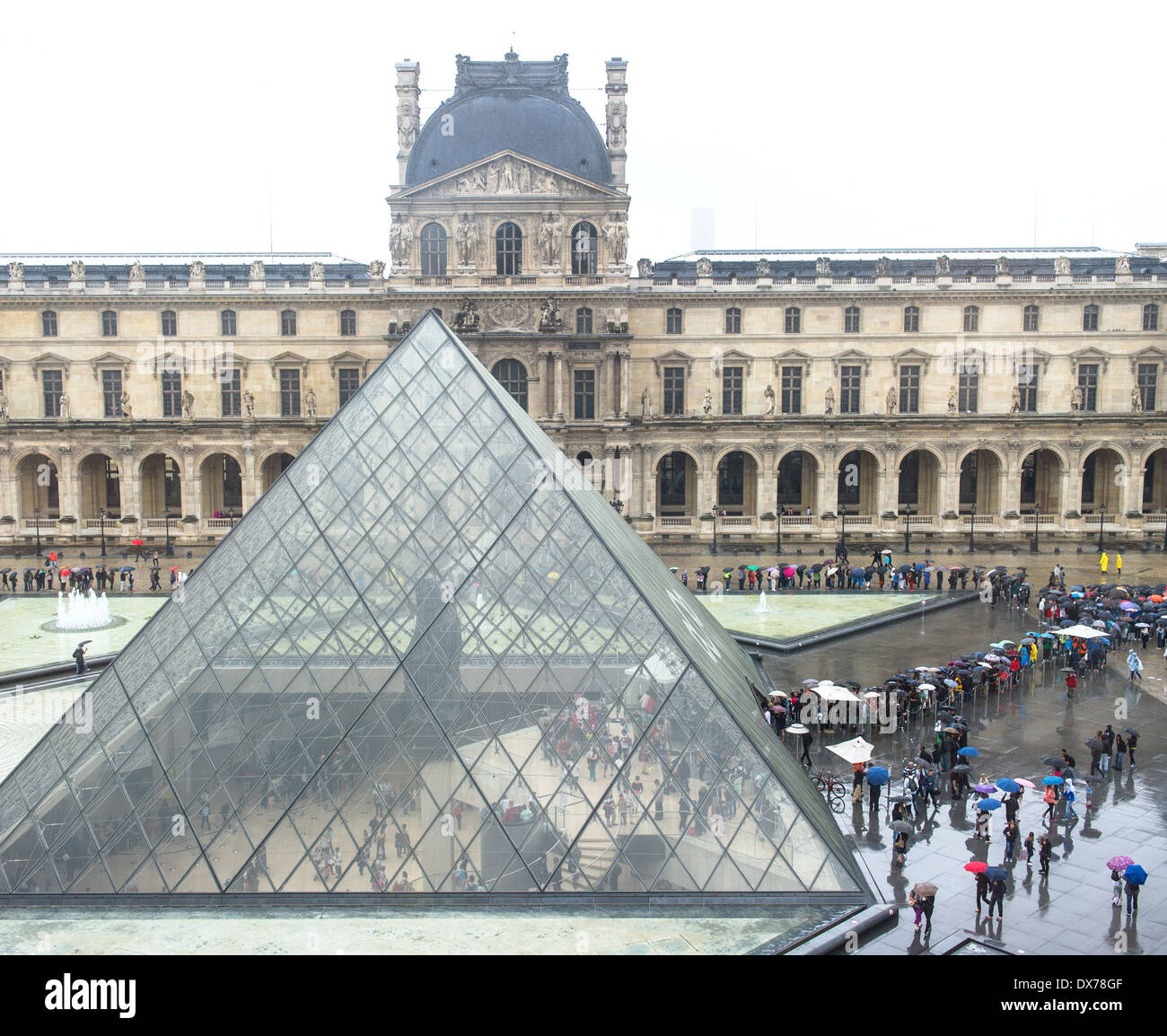 many tourists standing in a long line at the entrance to Louvre Museum ...
