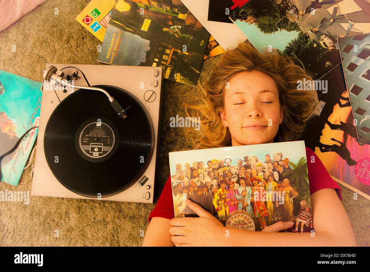 Pretty teenage girl in her bedroom enjoying her vinyl record collection ...