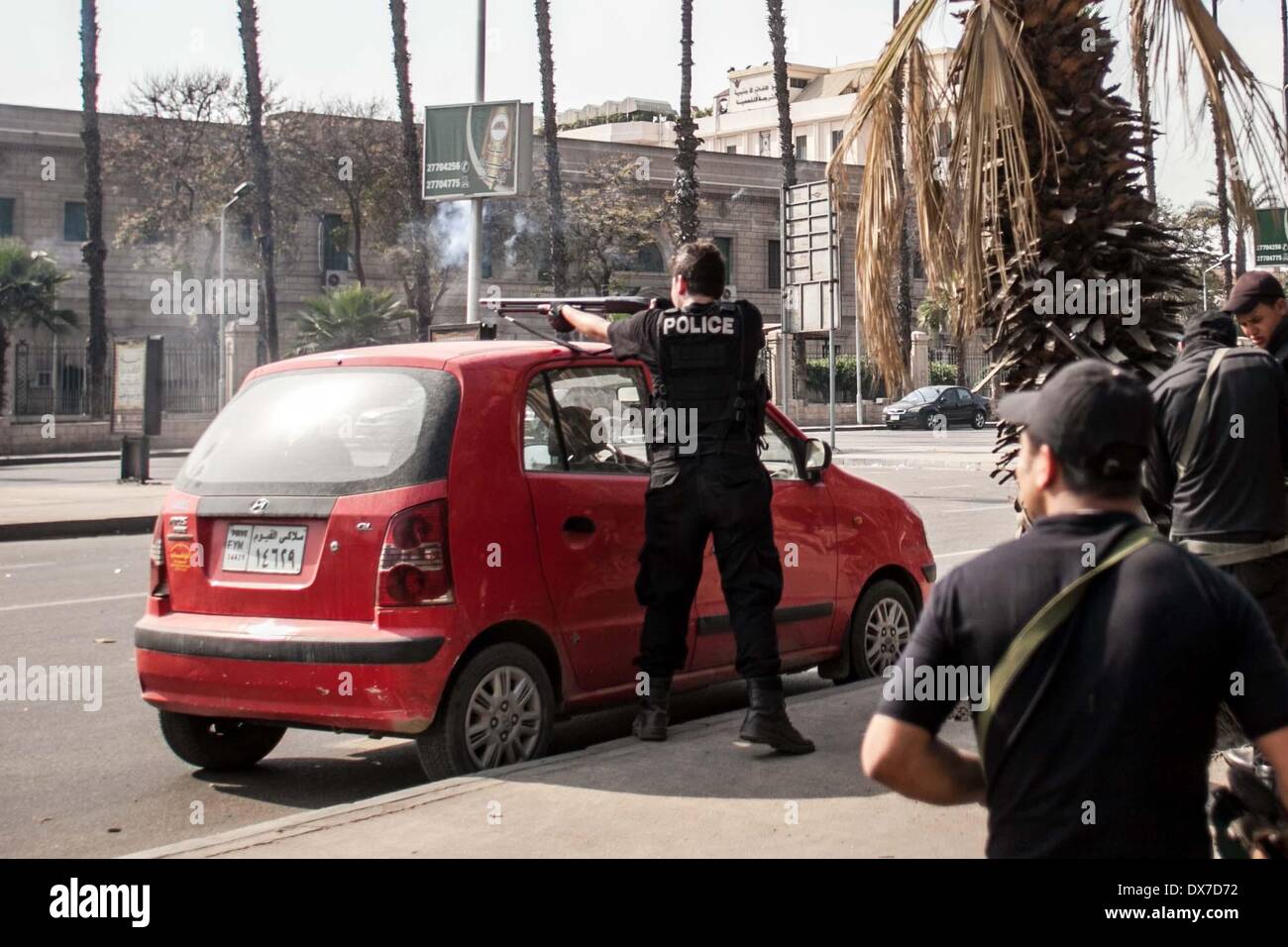 Cairo, Egypt. 19th Mar, 2014. A riot policeman fires tear gas to ...