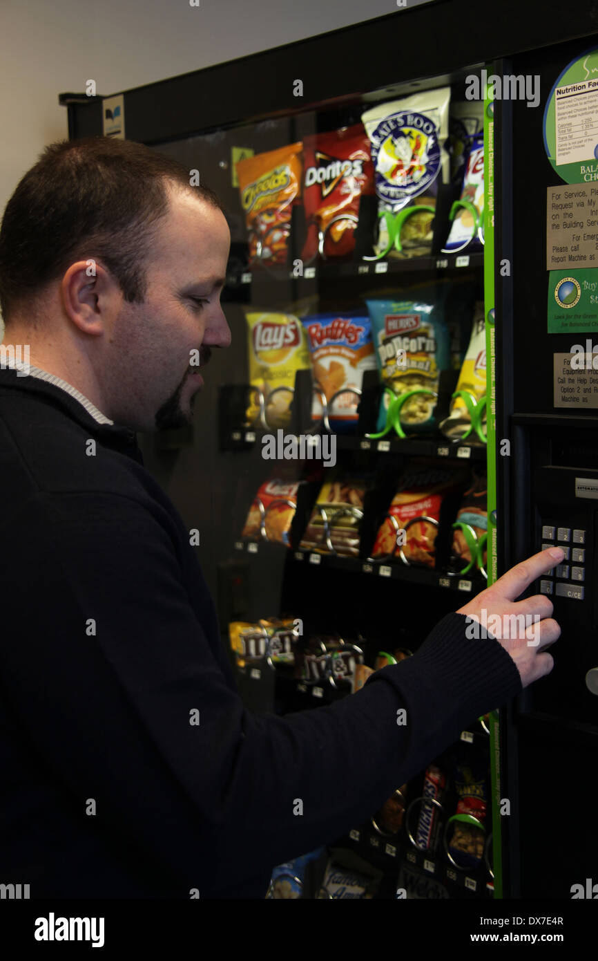 Man buying a junk food snack from a vending machine, New York, USA ...