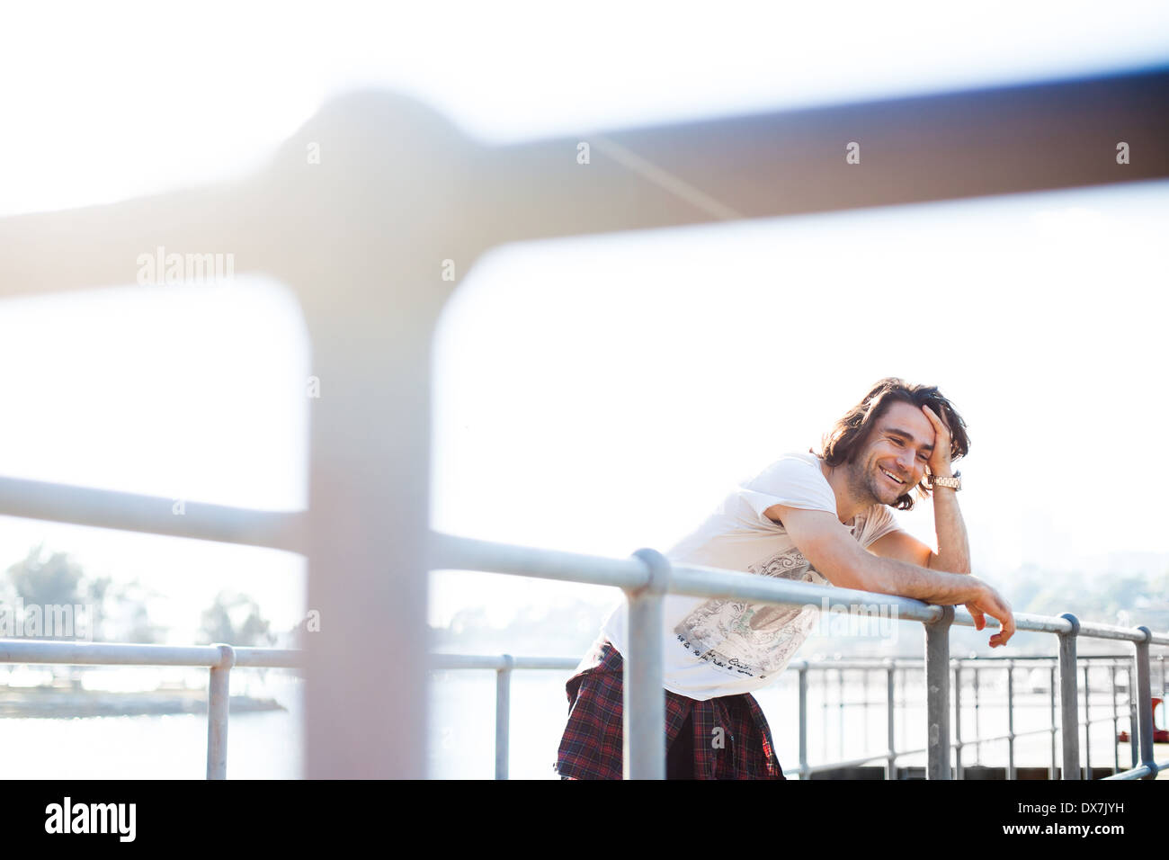 A healthy and happy young man leaning on railings near water Stock ...