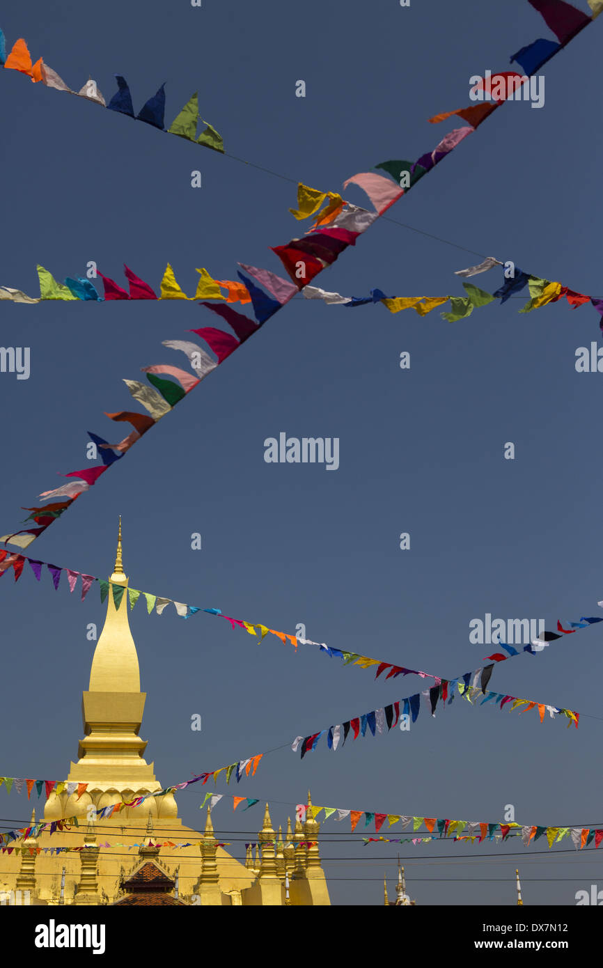 Pha That Luang Temple in Vientaine, Laos with colourful prayer flags ...