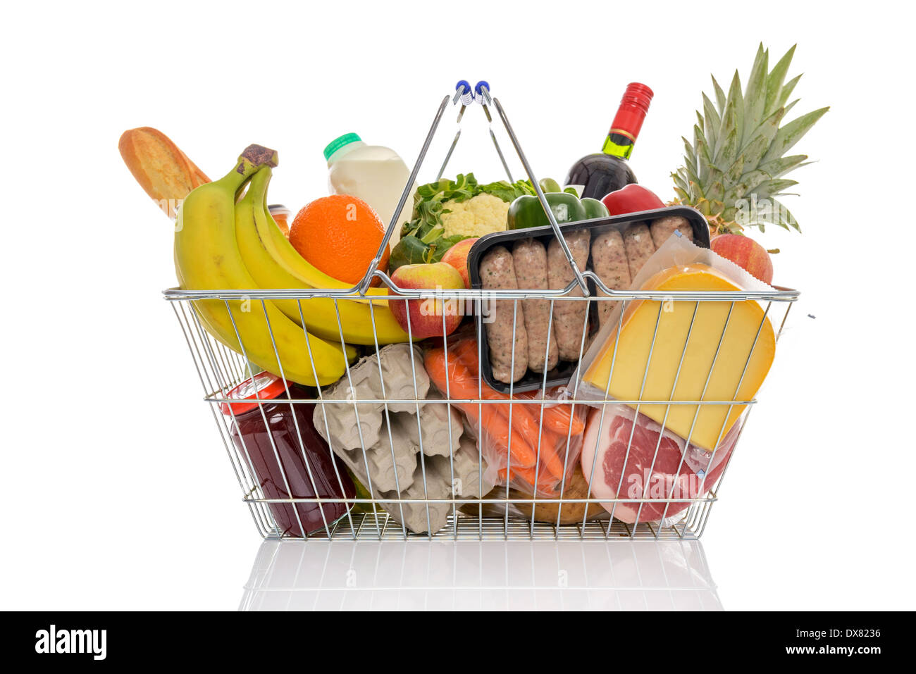 Wire shopping basket full of groceries including fresh fruit ...