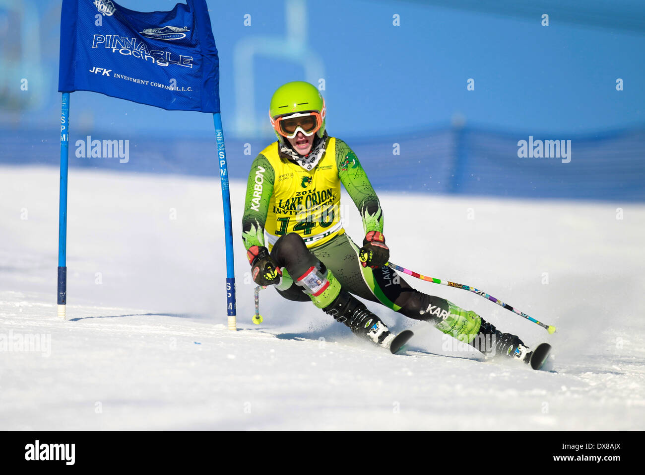 A snow skier turning at a gate while racing on the giant slalom course ...