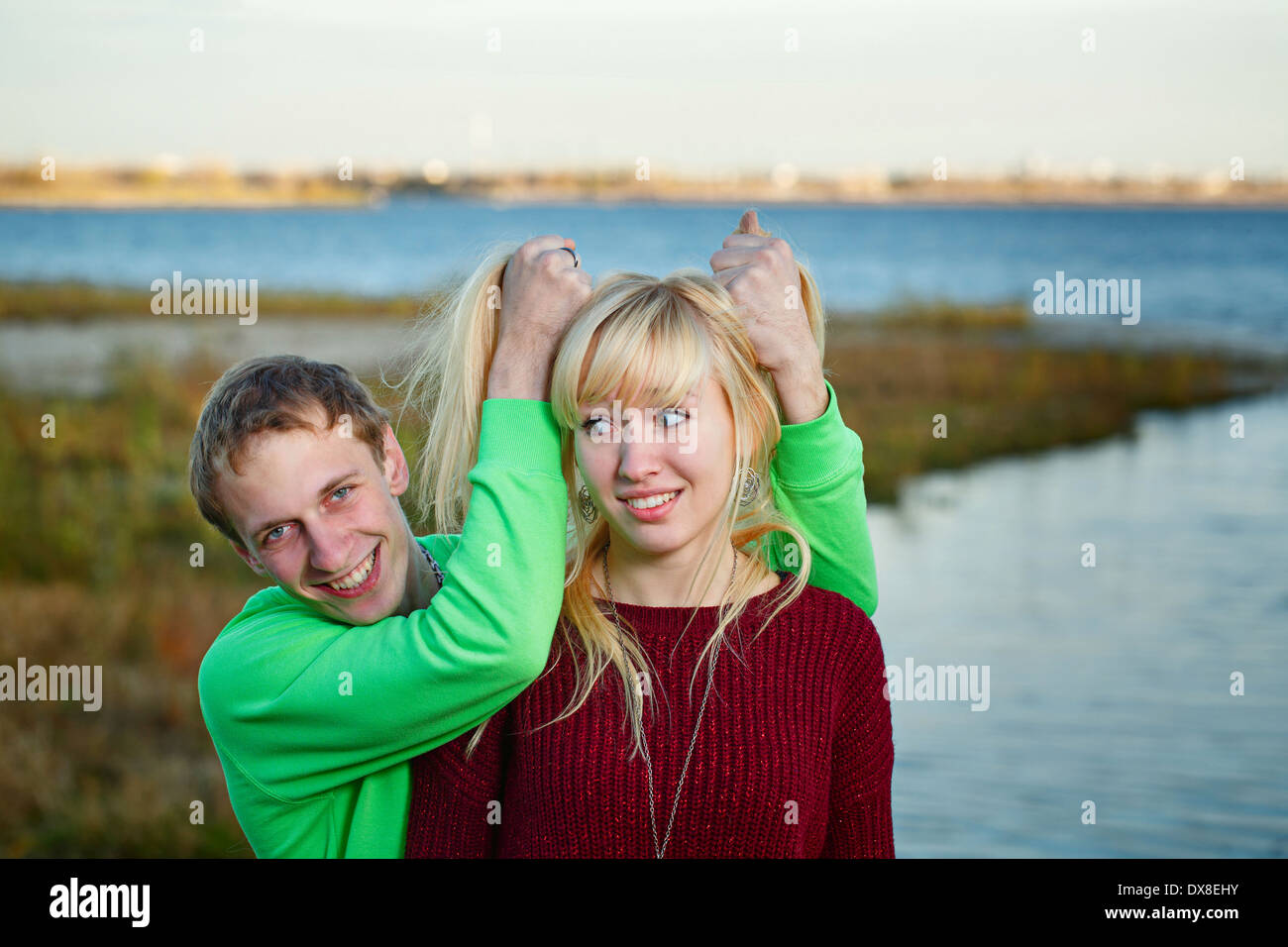 Young couple fooling around on the beach day in autumn Stock Photo - Alamy