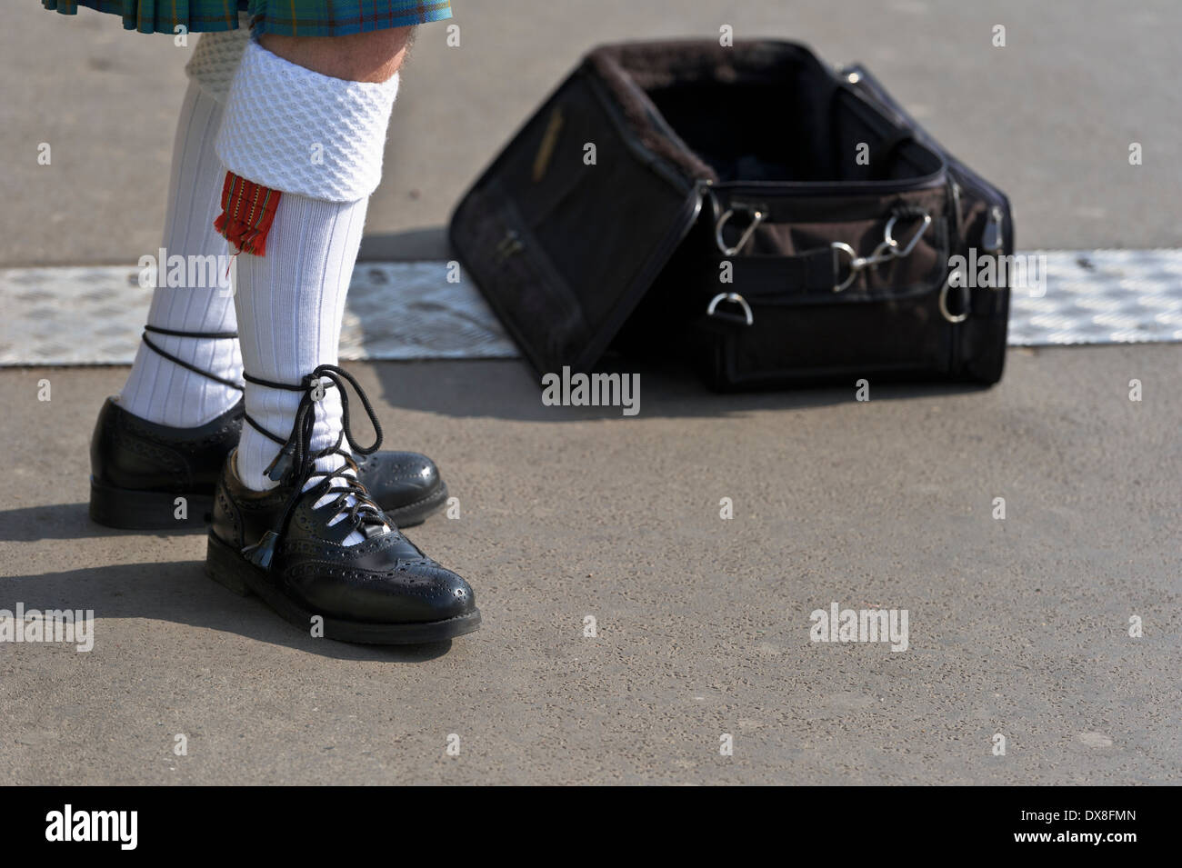 Man playing bagpipe wearing long white socks and Scottish black shoes ...