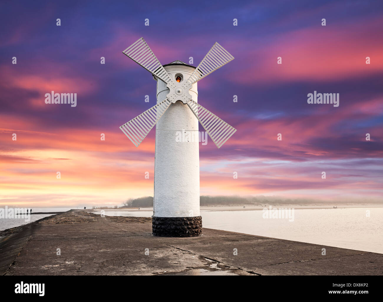 Lighthouse windmill with dramatic sunset sky, Swinoujscie, Baltic Sea ...
