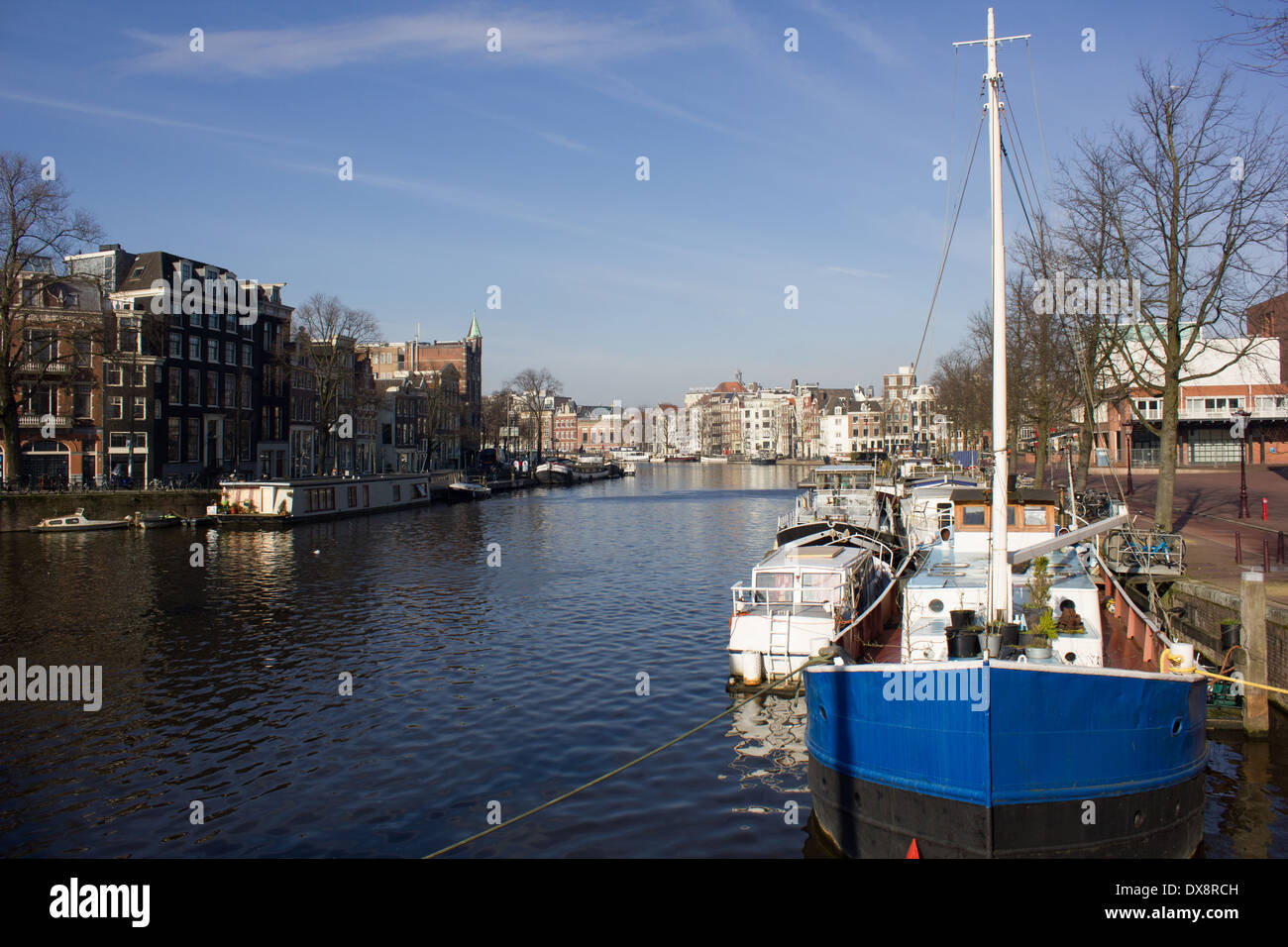 Dutch barge and boats on canal with traditional buildings on sunny day ...