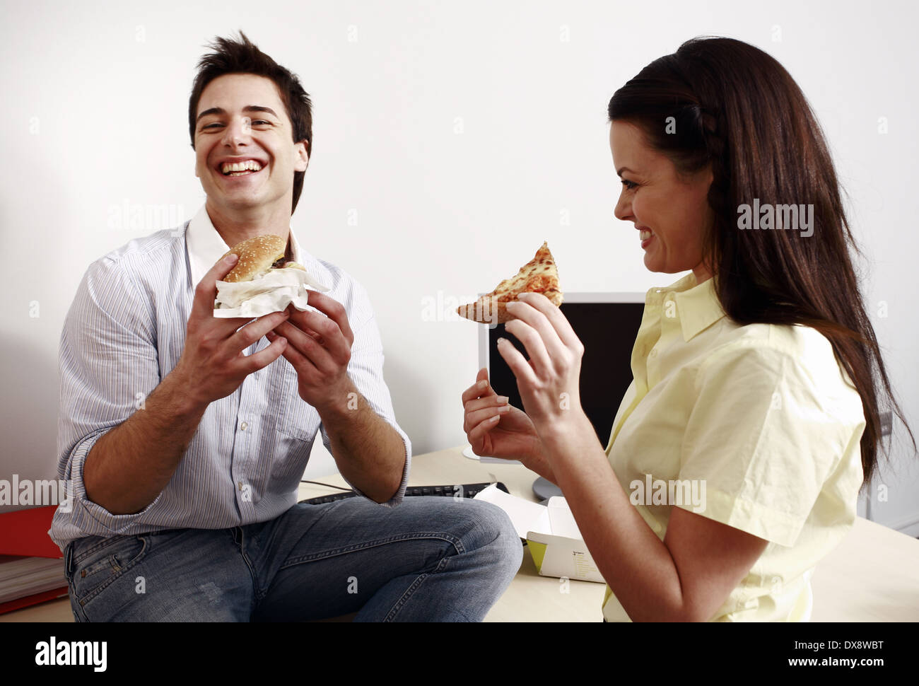 Male and female office workers eating take out food Stock Photo - Alamy