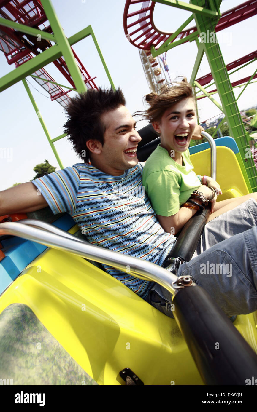 Teenage couple on amusement park ride Stock Photo - Alamy
