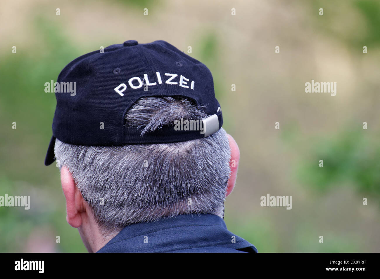 Male German police officer seen from behind wearing a hat marked ...